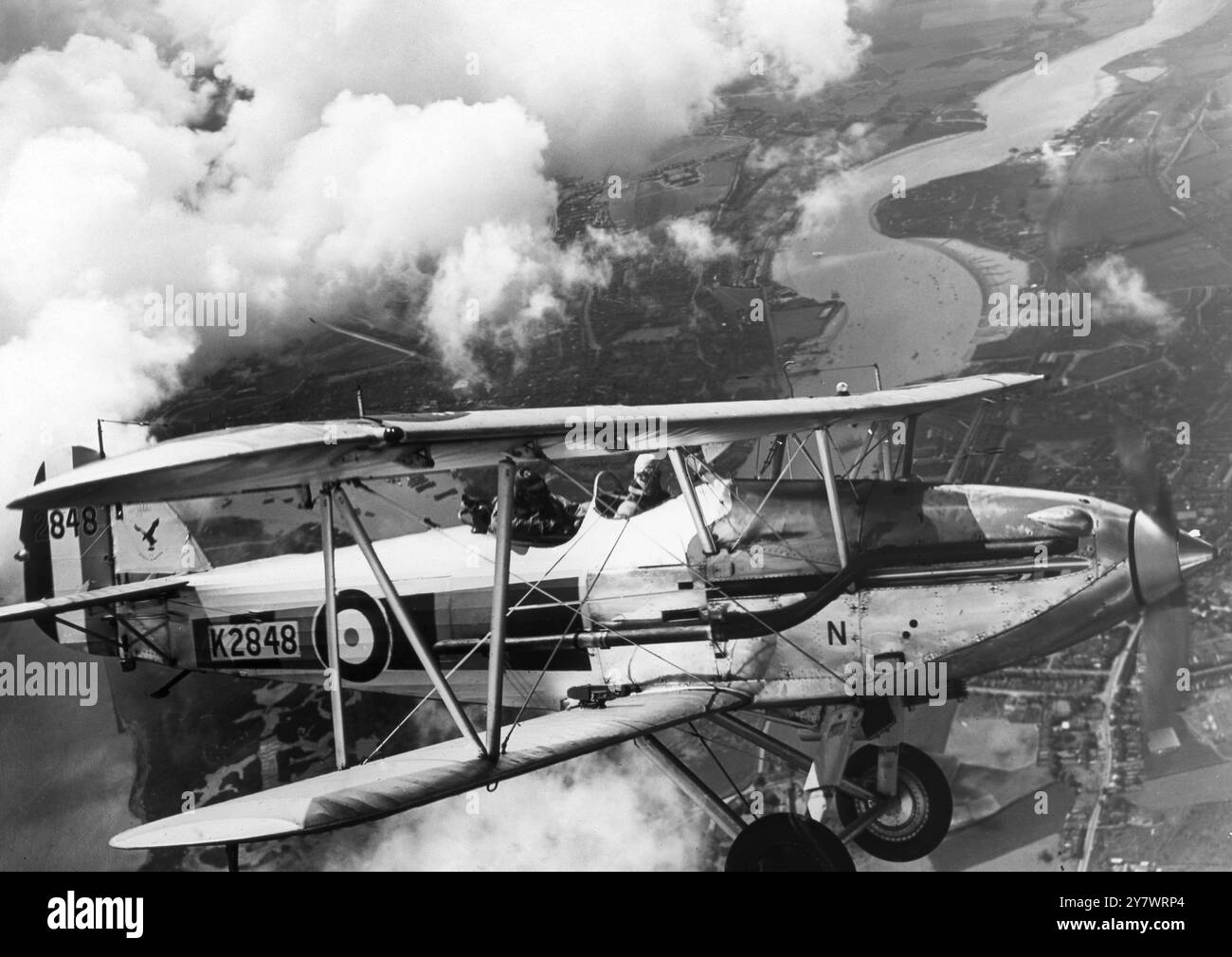 Biplane flying above river Thames with clouds in the background Stock ...