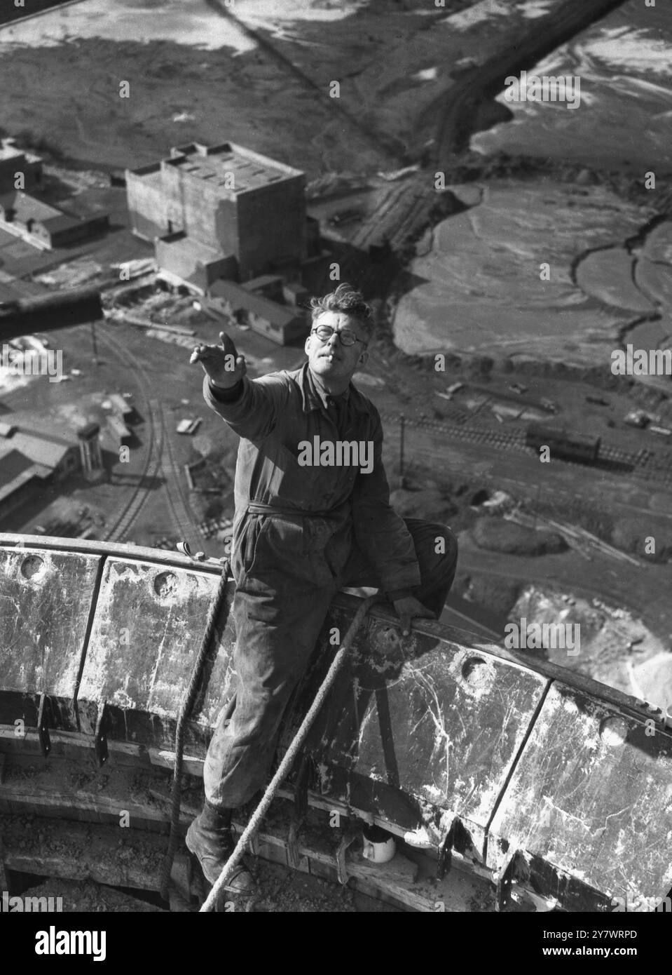 Man on top of chimney stack - in the process of climbing on or off ...