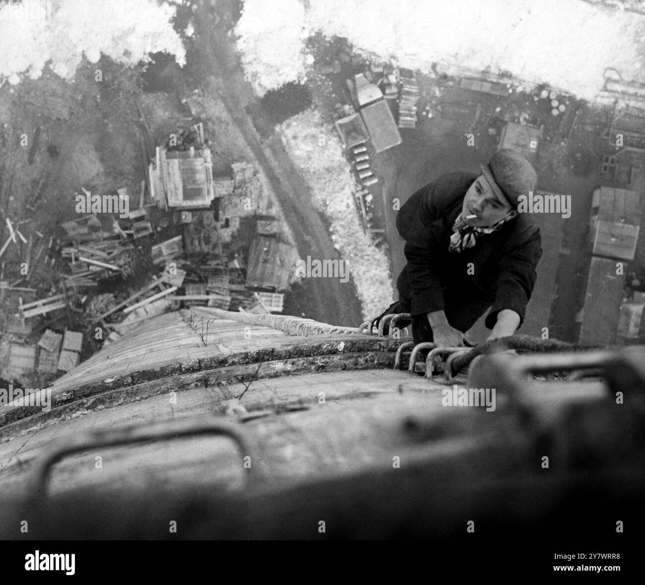 Man on top of chimney stack - in the process of climbing on or off - no ...