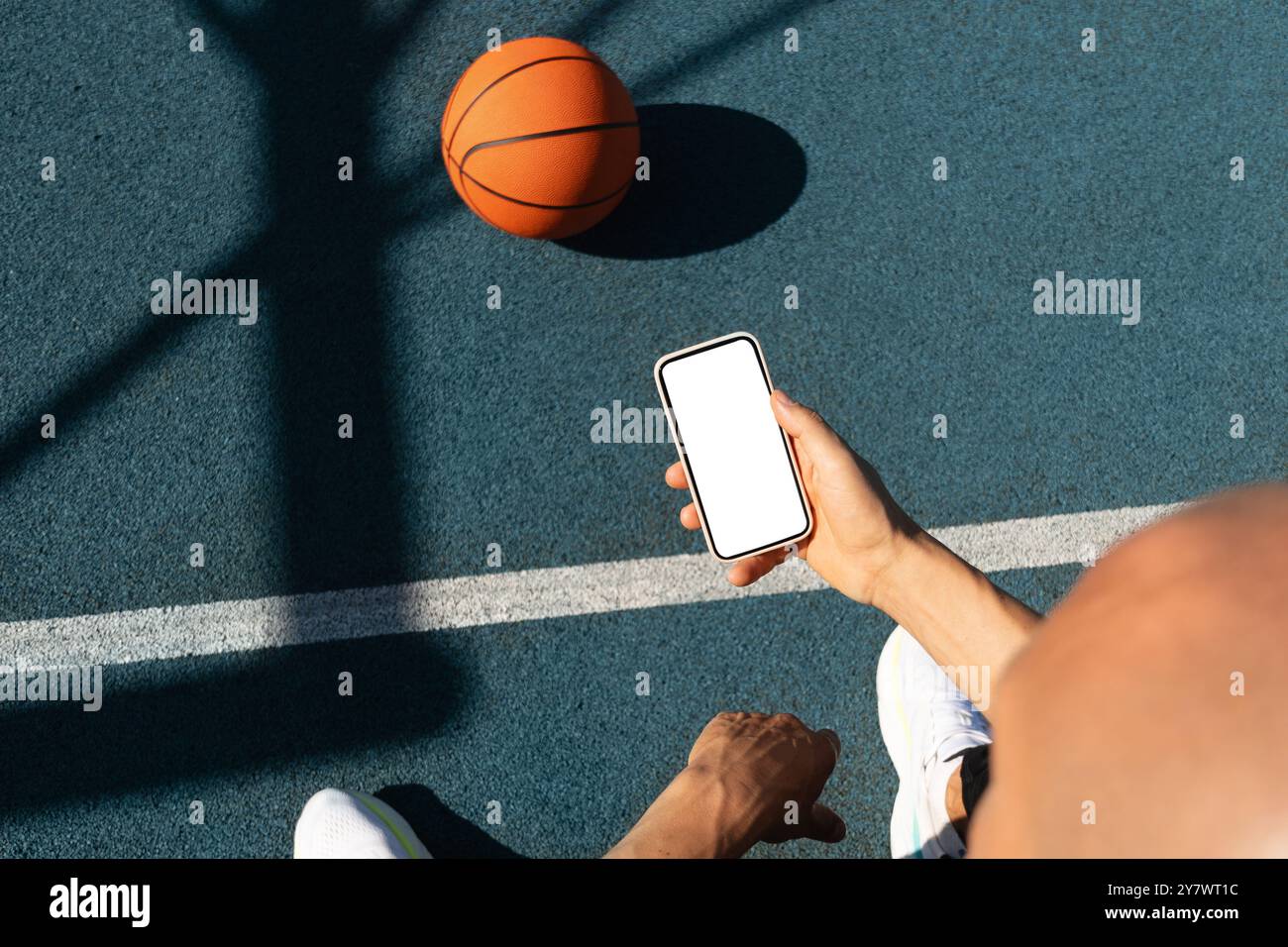 Smartphone in hands basketball player during game interval. Blank ...