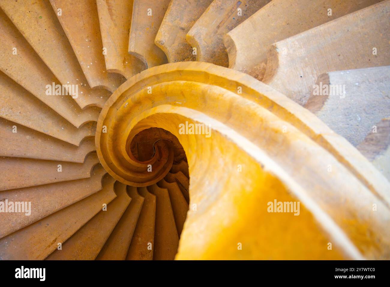 A stunning helical staircase with smooth, yellow steps spirals ...