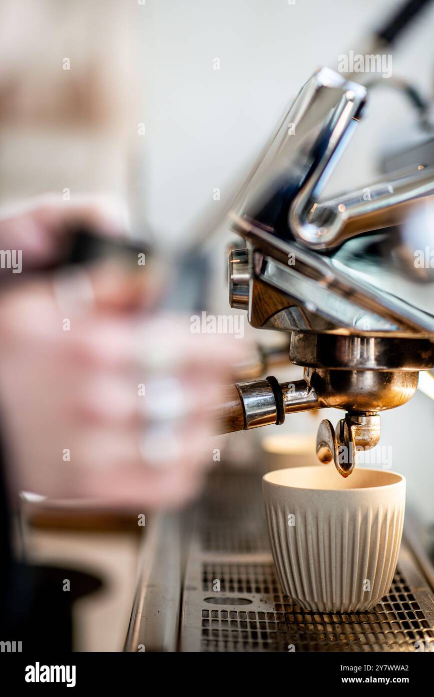 Modern coffee machine in a minimalist-style coffee shop. A man's hand ...