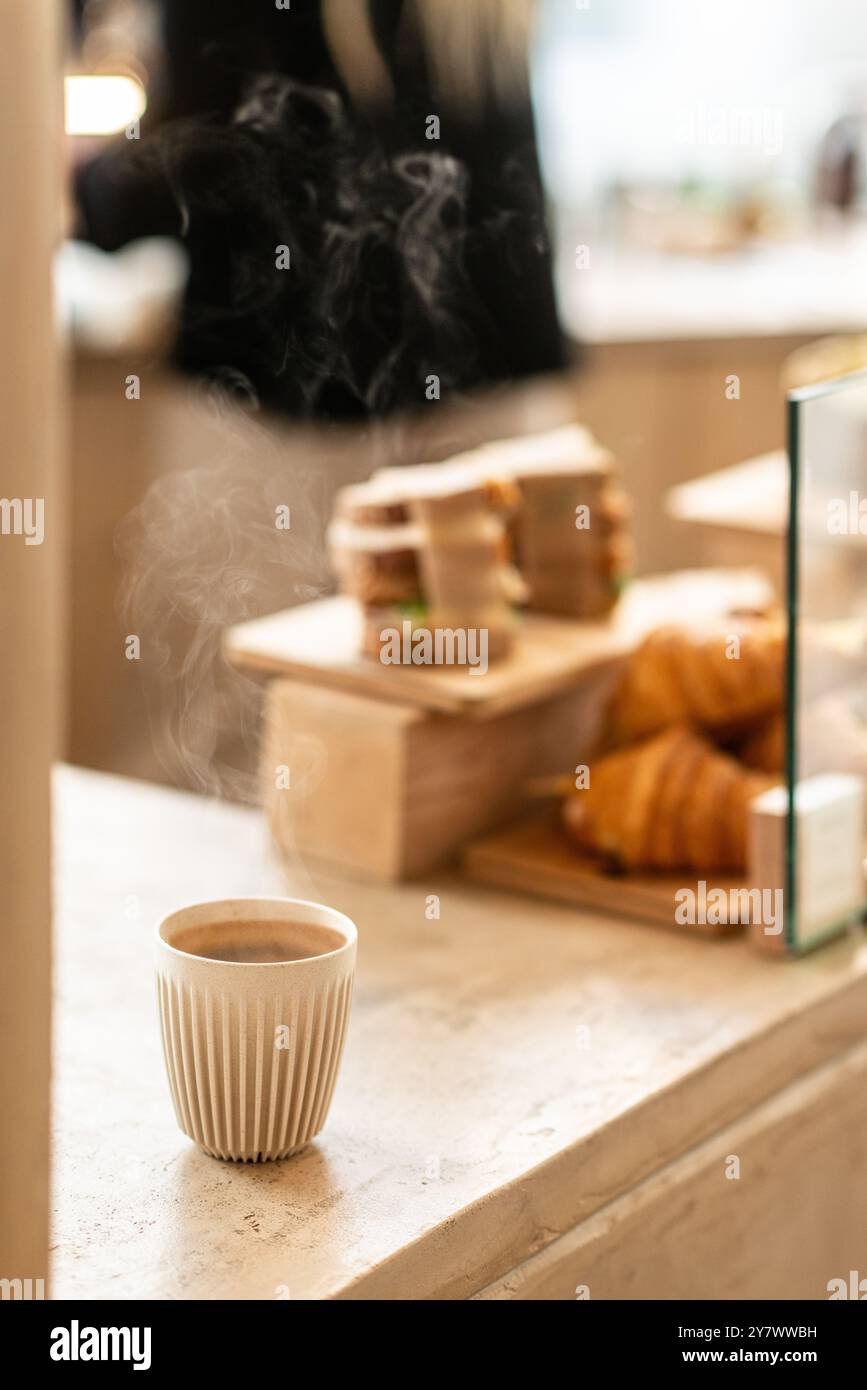 Steaming cup of coffee in a minimalist coffee shop. Side view Stock ...