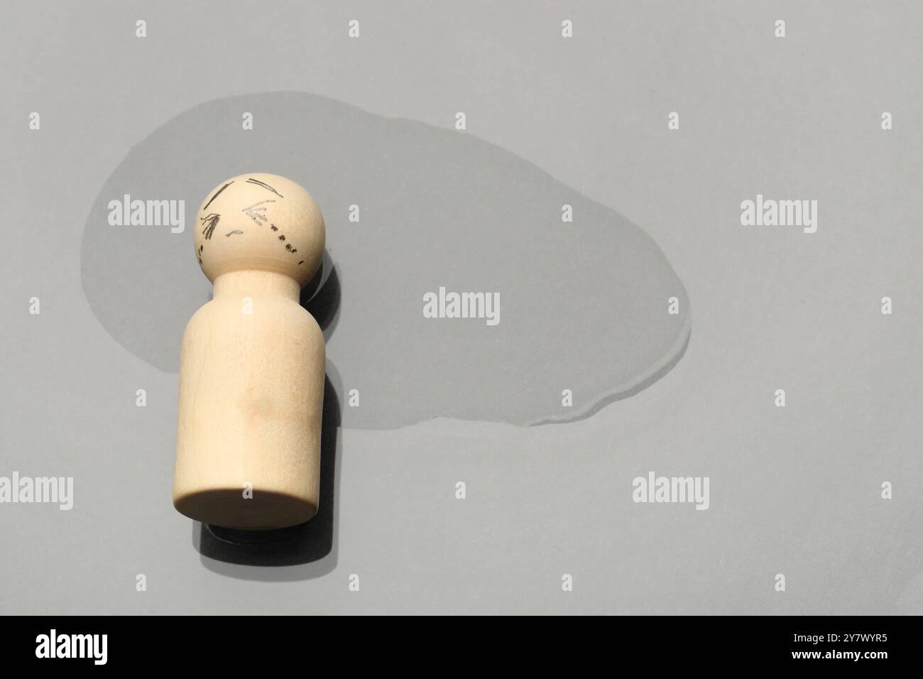 Loneliness concept. Human figure with crying face in puddle of tears on ...