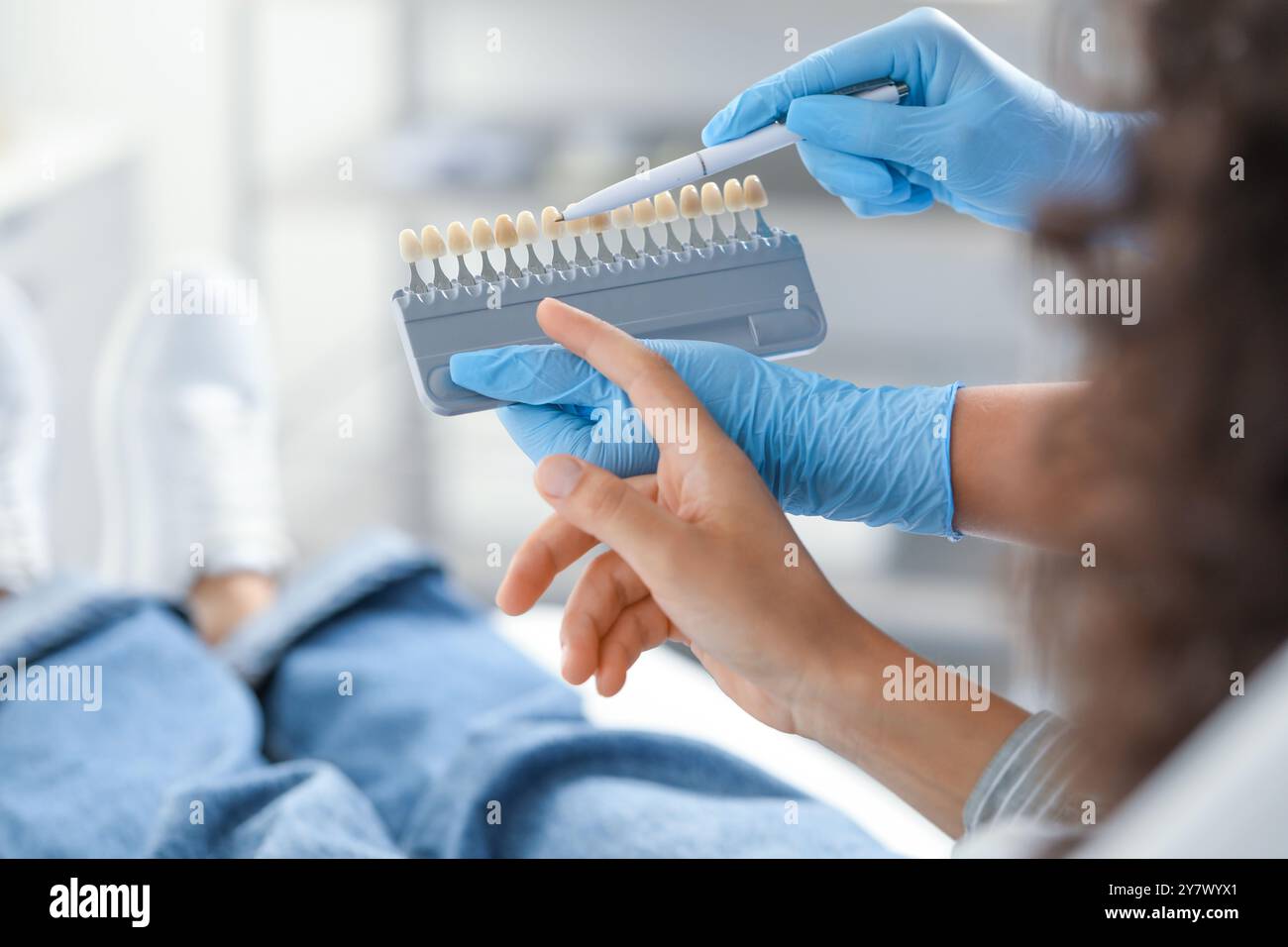 Doctor and patient choosing shade on teeth color palette in clinic ...