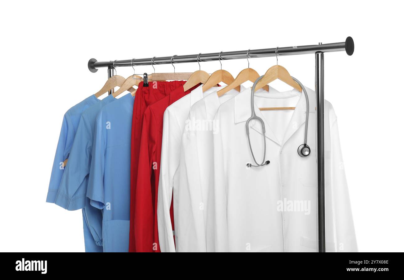 Different medical workers' uniforms and stethoscope on clothing rack ...