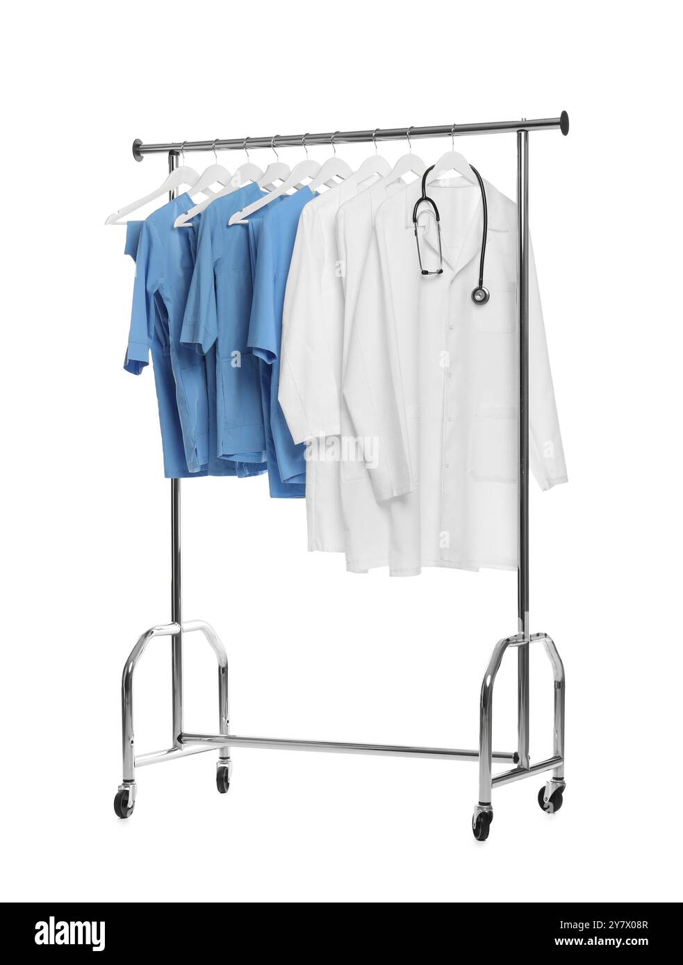 Different medical workers' uniforms and stethoscope on clothing rack ...