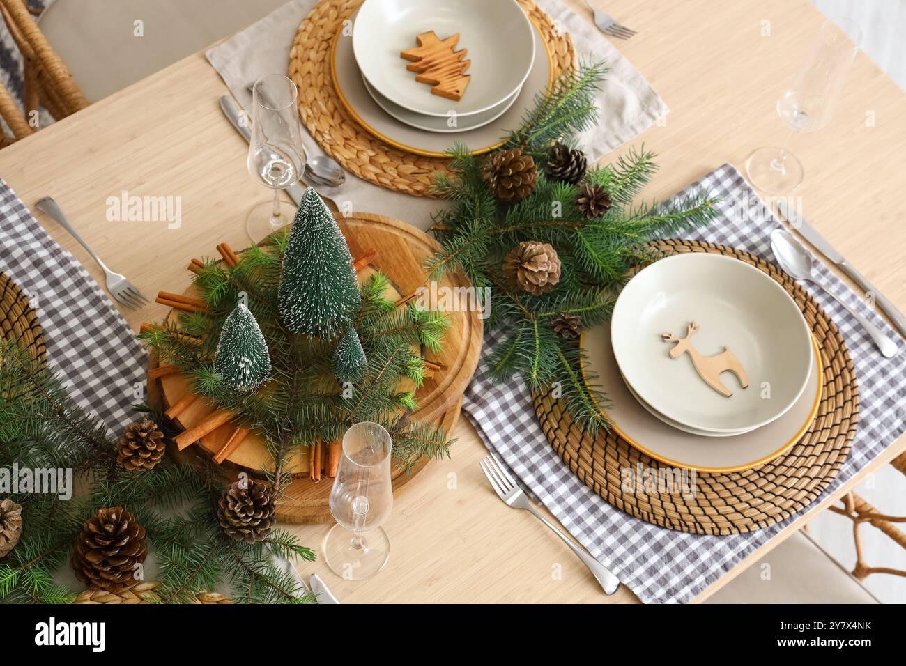 Christmas table setting with fir tree branches, pine cones, plates and ...