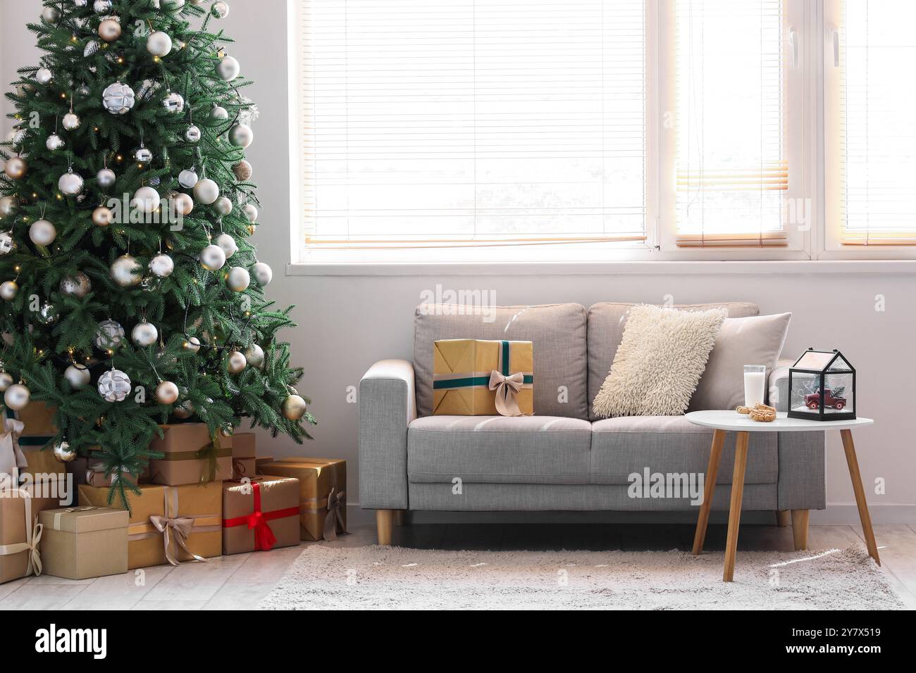 Interior of festive living room with grey sofa and gift boxes under ...