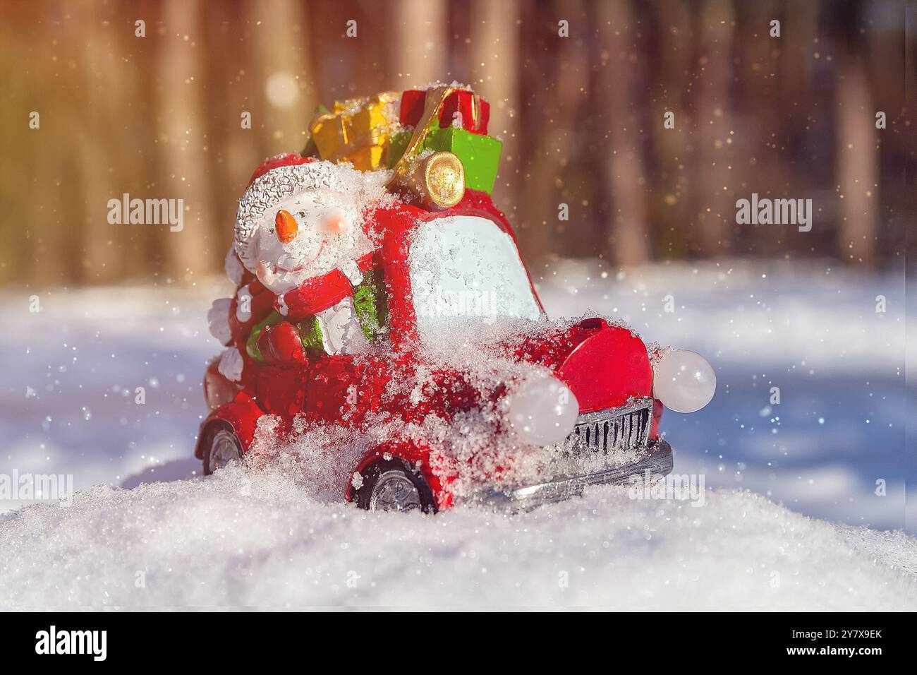Snowman and retro red car with gift boxes on the background of a snowy ...