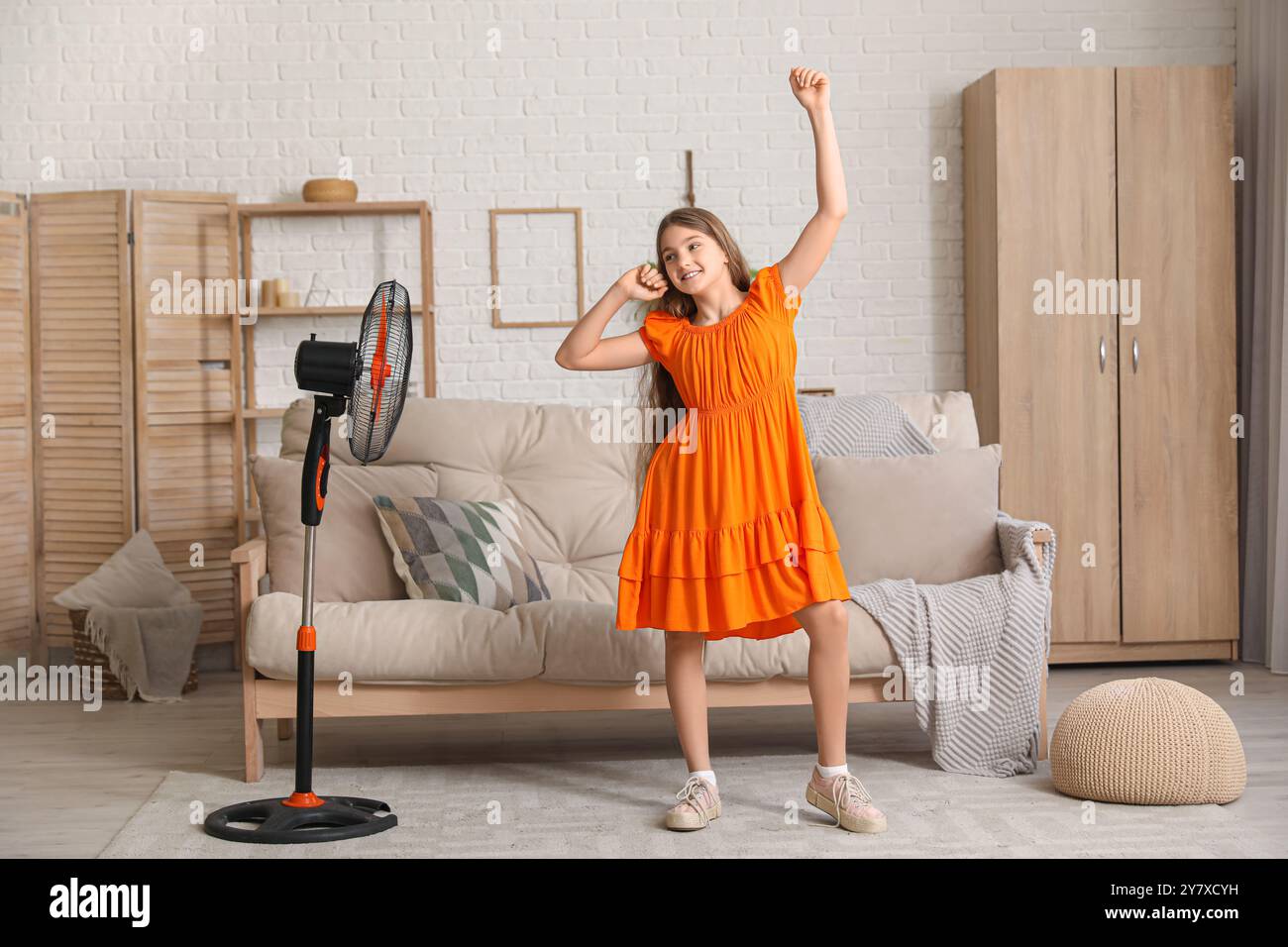 Teenage girl dancing near electric fan in living room Stock Photo - Alamy