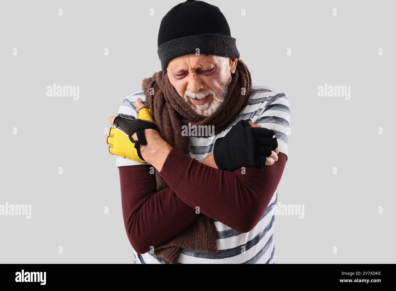 Frozen homeless man on light background Stock Photo - Alamy