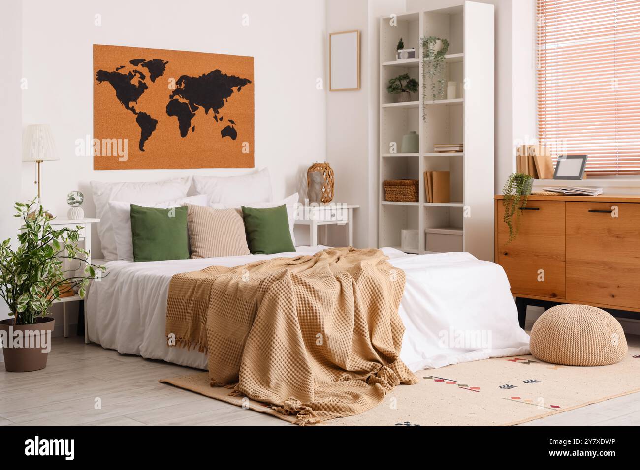 Interior of bedroom with comfortable bed, shelving unit and world map ...
