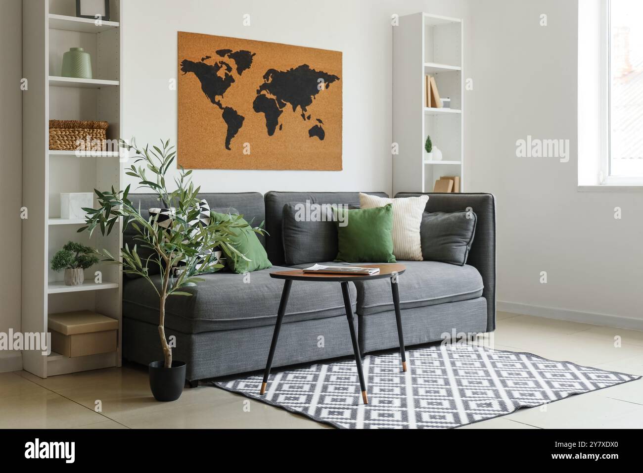 Sofa, table, shelving units and world map on white wall in living room ...