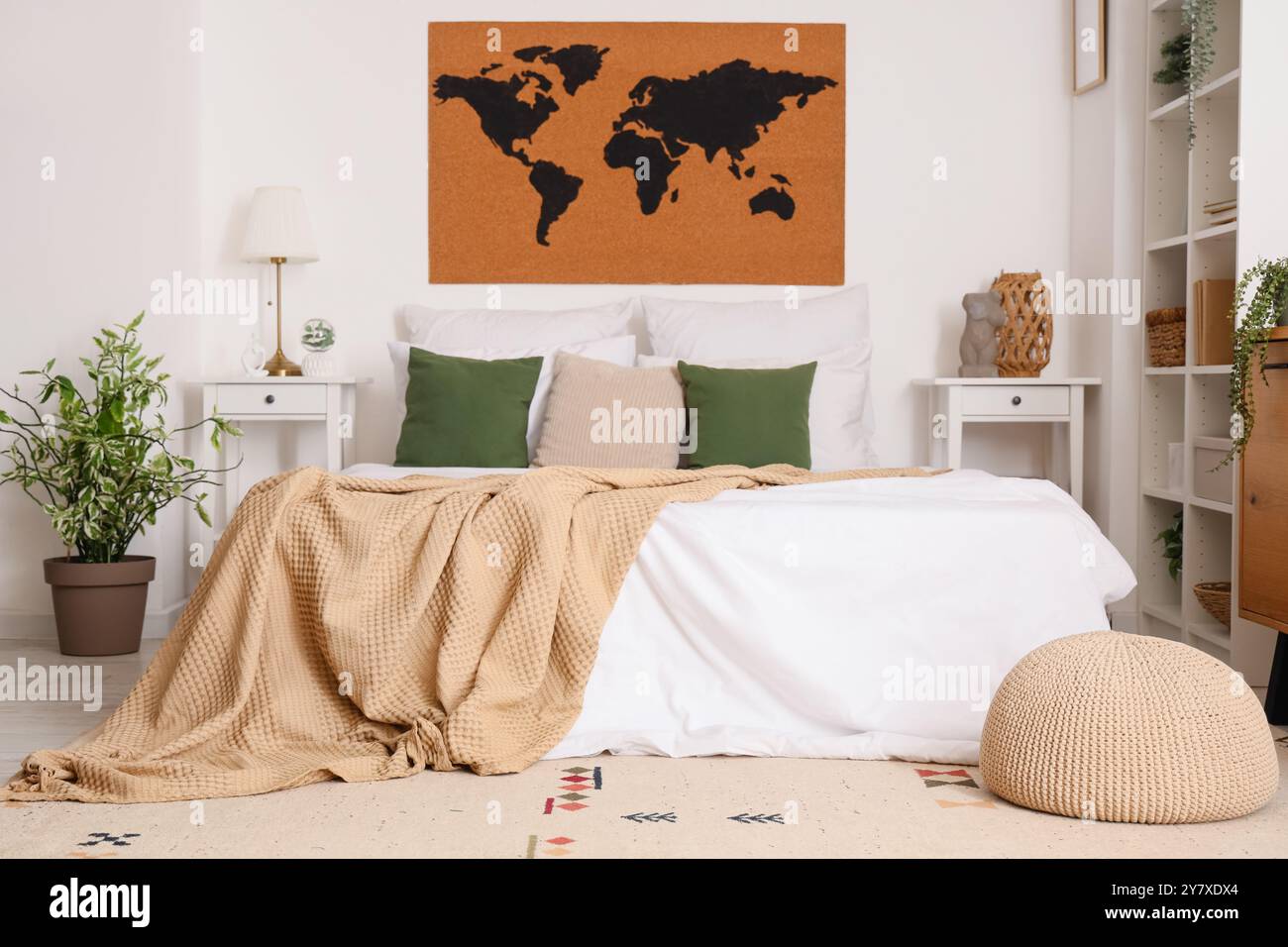 Interior of bedroom with comfortable bed, pouf and world map on white ...