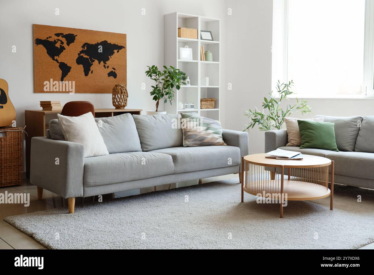 Comfortable sofas, table and world map in interior of living room Stock ...