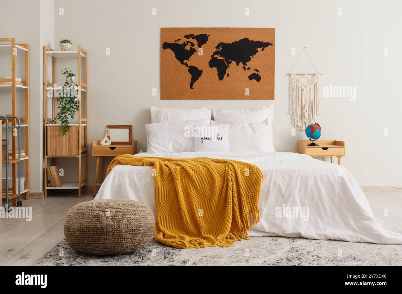 World map on wall, bed, pouf and shelving units in interior of light ...