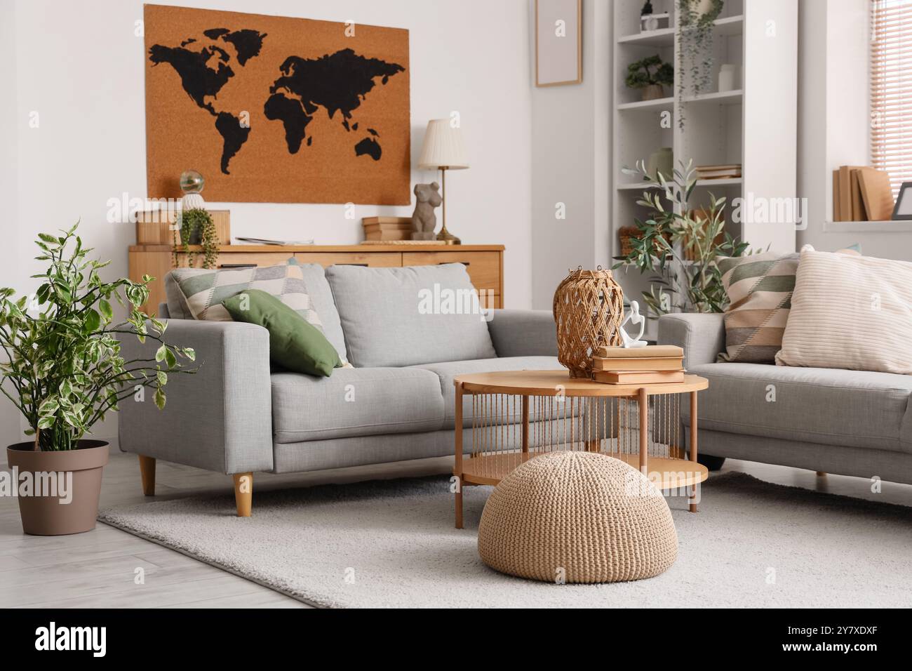 Interior of living room with comfortable sofas, pouf, table and world ...
