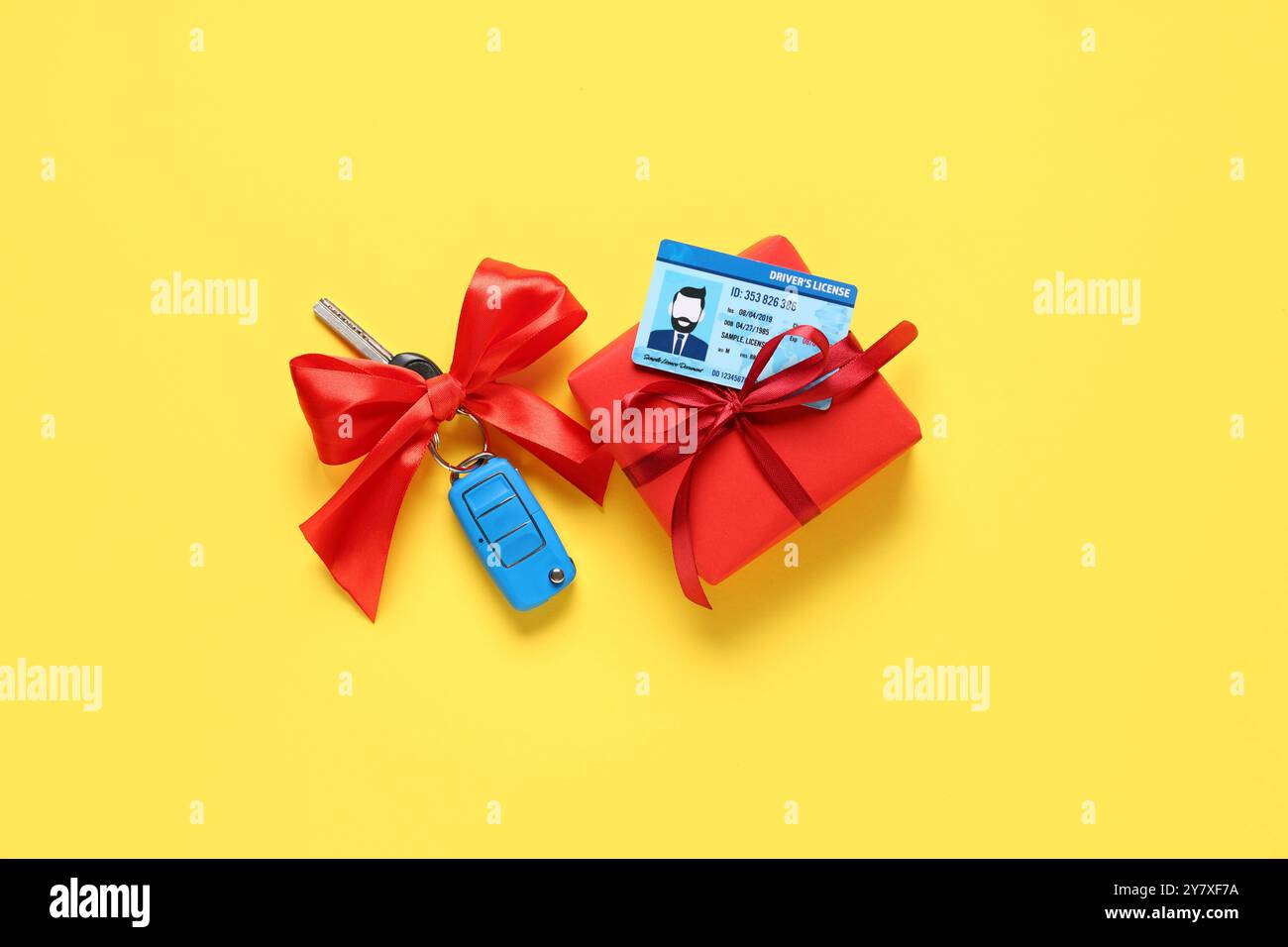 Gift box with keys of new car and driving license on yellow background ...
