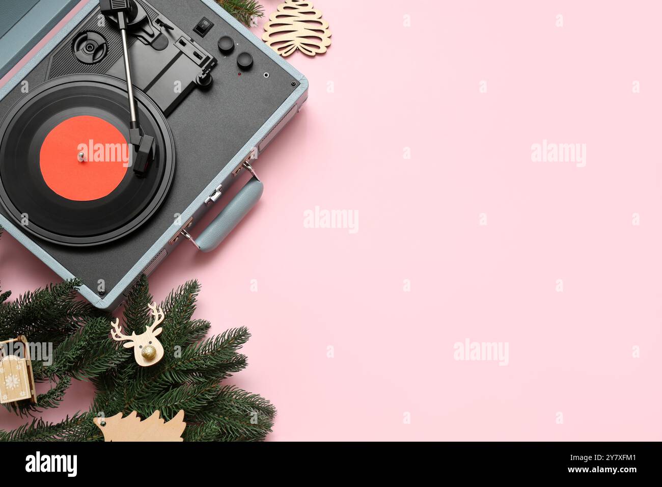 Vinyl record player with fir branches and Christmas decorations on pink ...