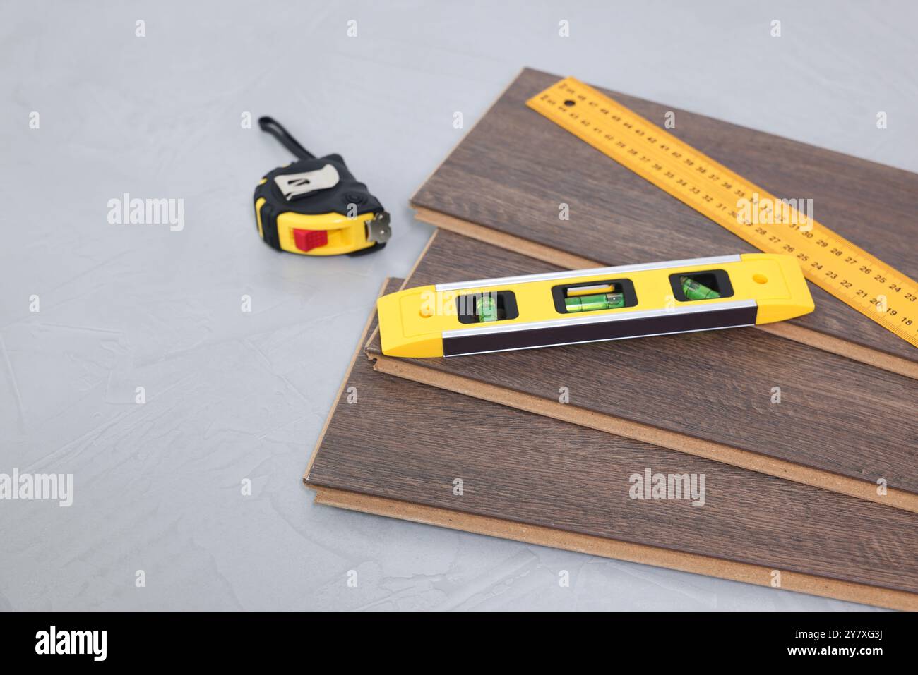 Different measuring tools and laminate flooring pieces on grey textured ...