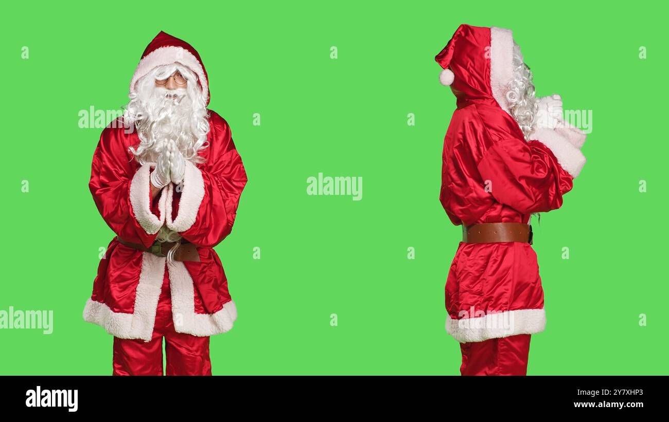 Faithful santa claus praying in studio, holding hands in a prayer and ...