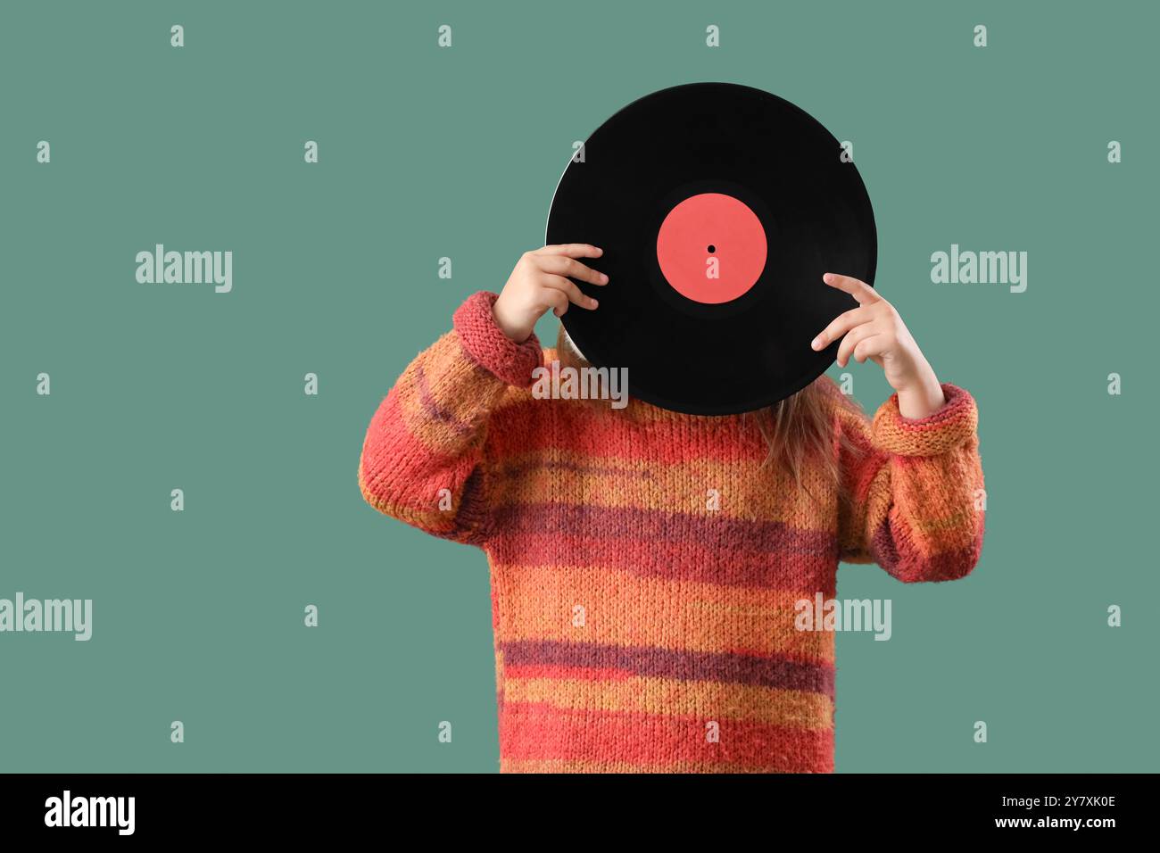 Cute little girl with vinyl disk for record player on green background ...