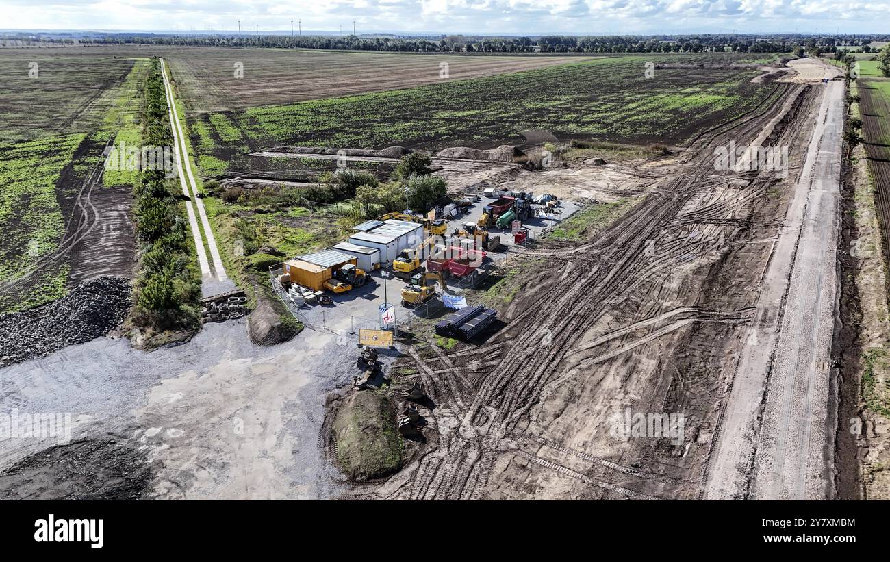 Construction vehicles are parked on an access road under construction ...