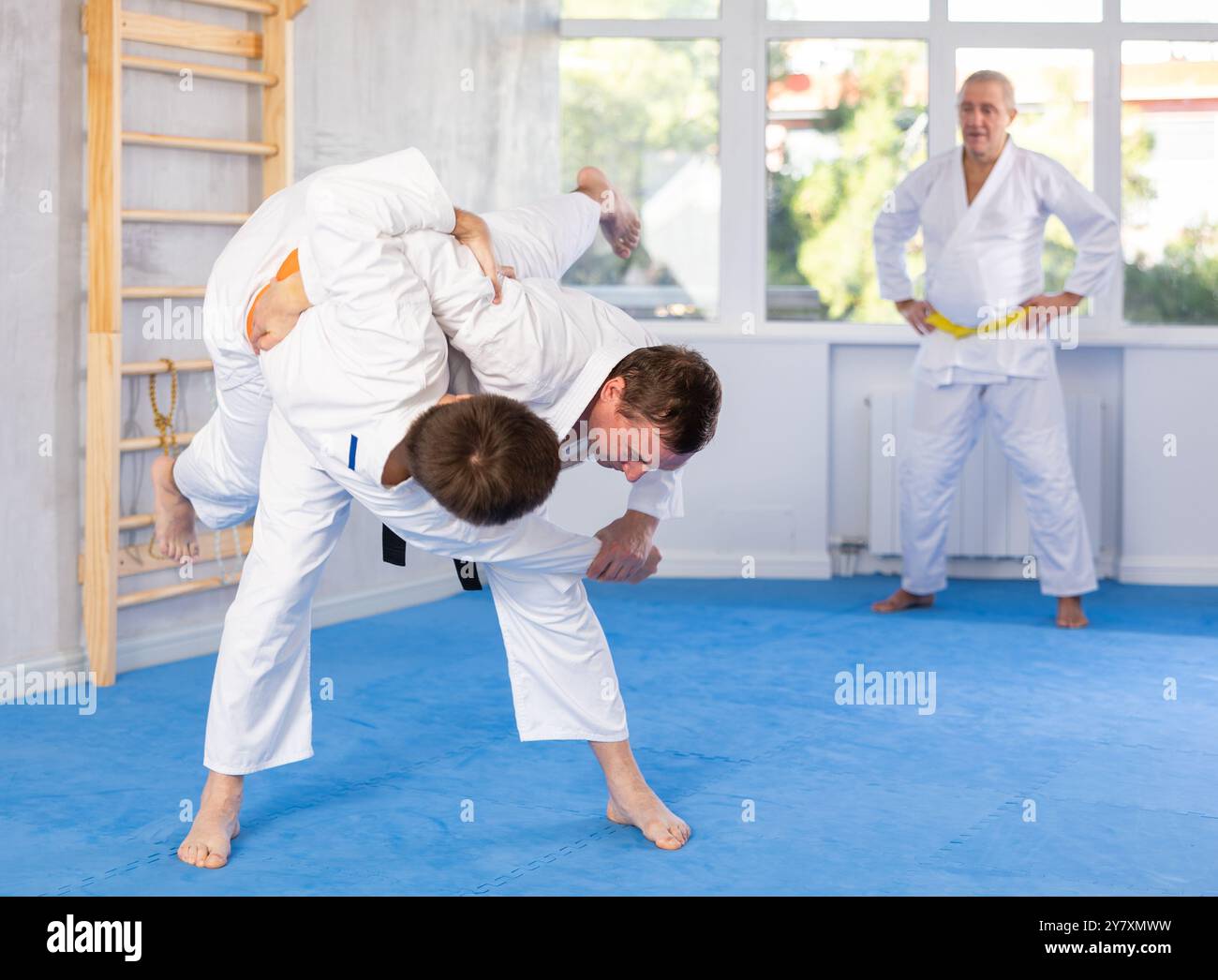 Adult and young men training judo fight Stock Photo - Alamy