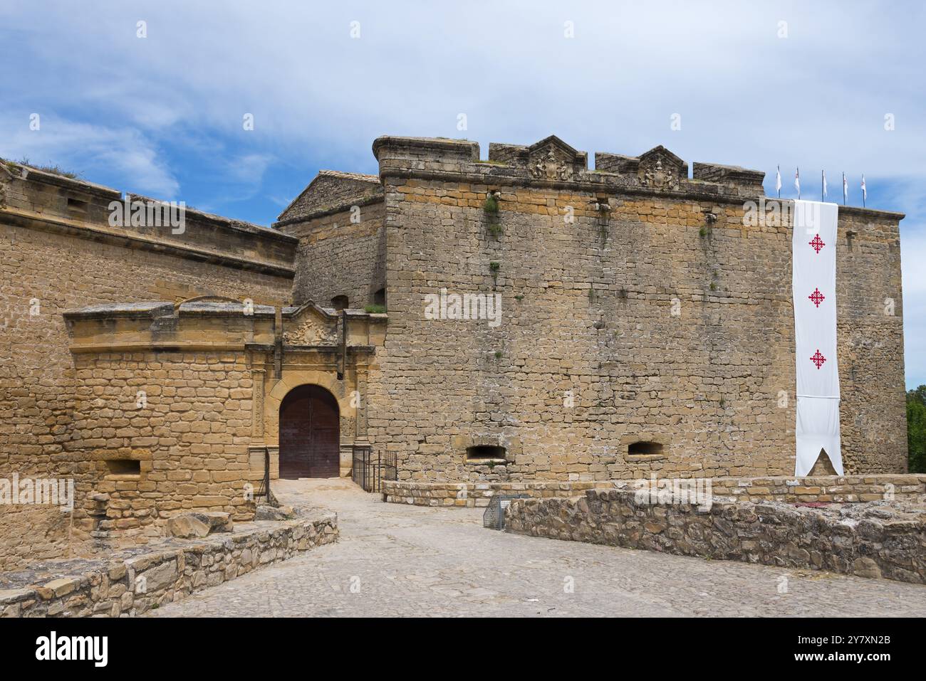 Massive medieval stone castle with a red cross banner indicating its ...