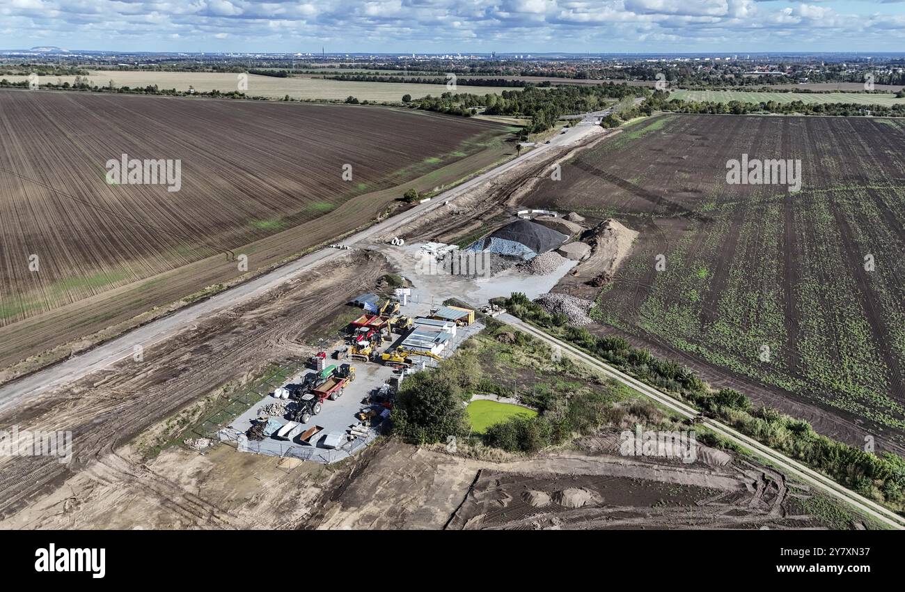 Construction vehicles are parked at an access road under construction ...