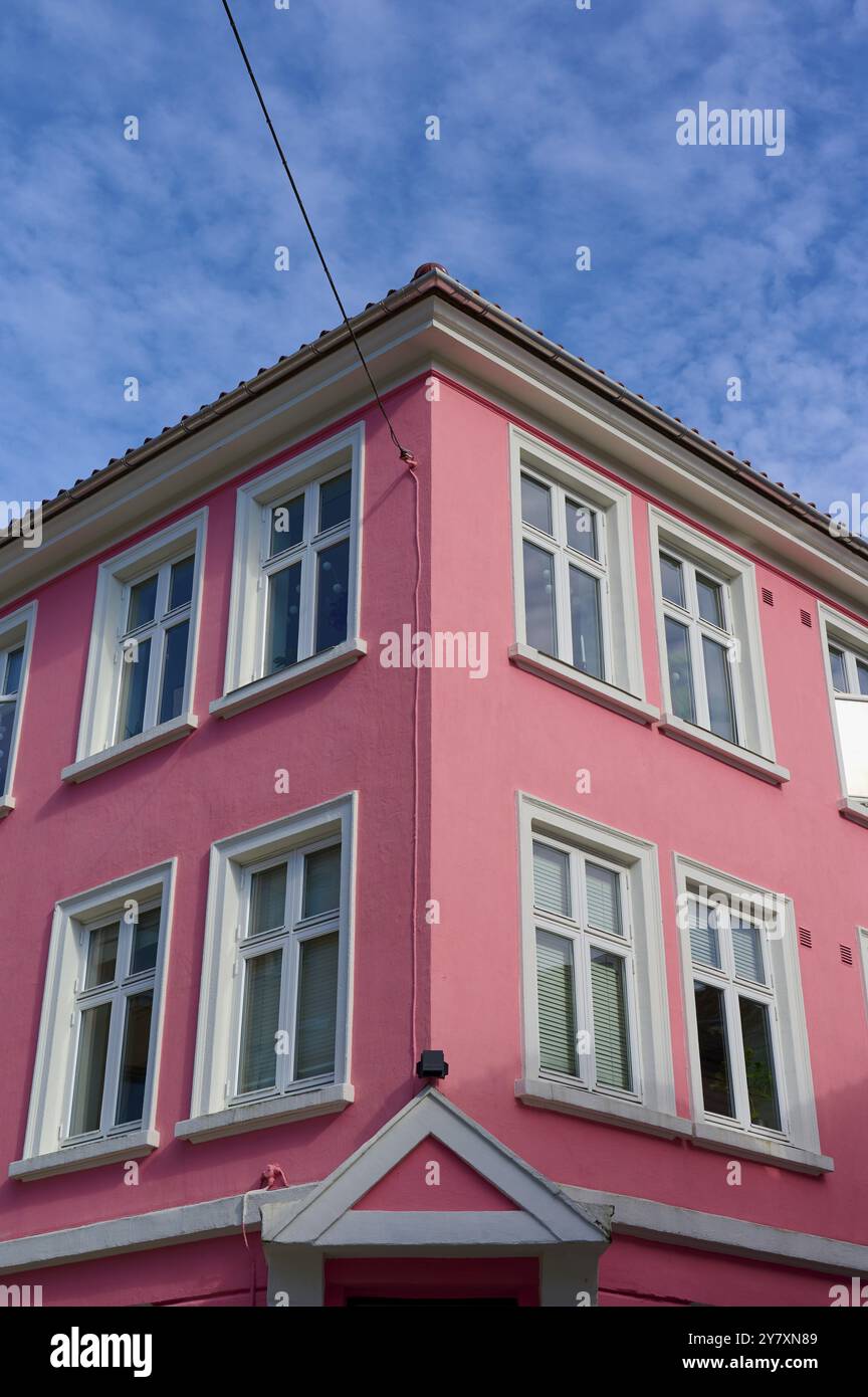 Historic building with pink facade and white window frames under a blue ...