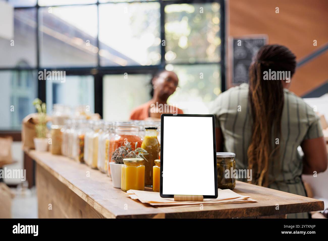 Tablet with isolated white screen vertically positioned near glass ...