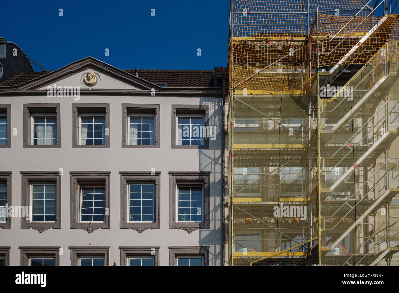 A building undergoing renovation. On the left, a well-preserved section ...