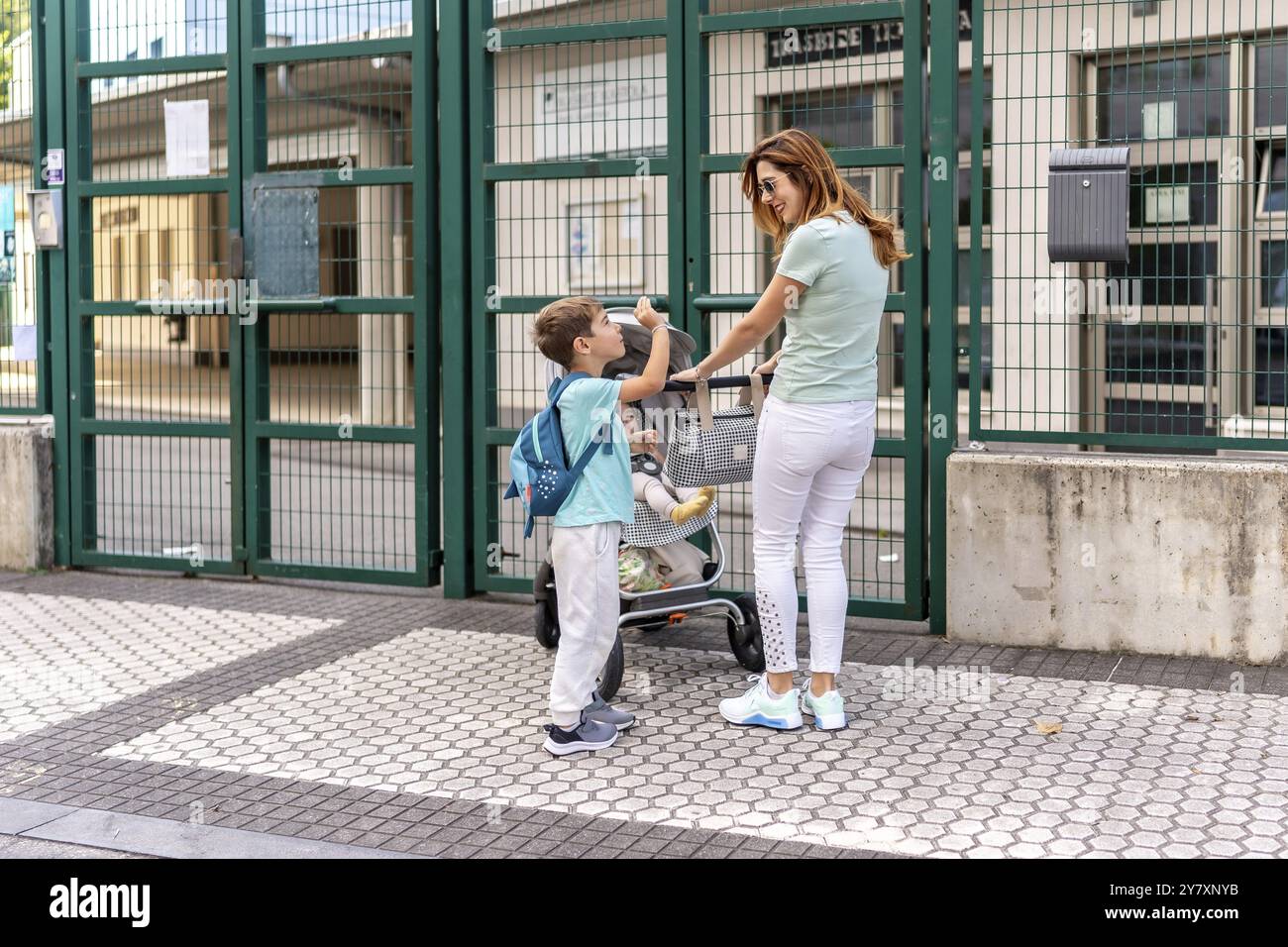 Boy high-fiving and saying goodbye to his mother and little baby ...