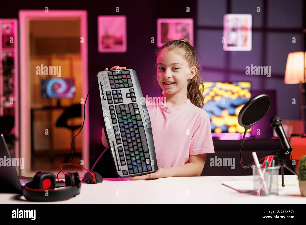 Happy charismatic girl presenting latest gaming computer peripheral ...