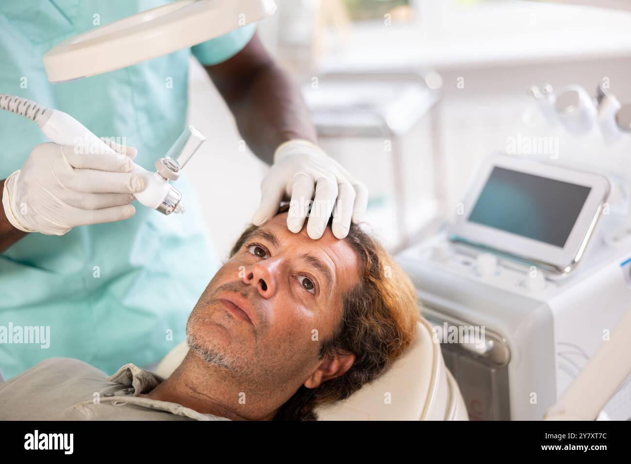 European man undergoes facial skin moisturizing procedure with hydrogen ...