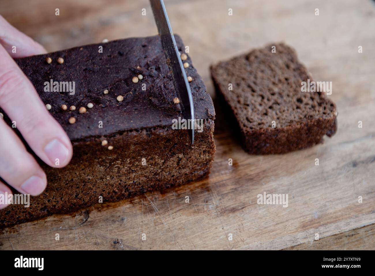 Sliced rye bread stock photo. The man cuts whole-wheat rye bread on a ...