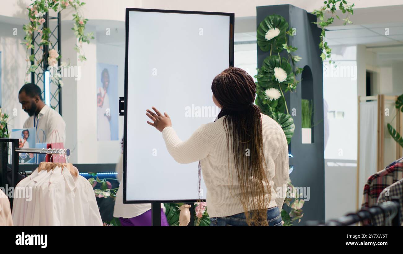 Customer in high tech thrift shop using digital isolated screen to find ...