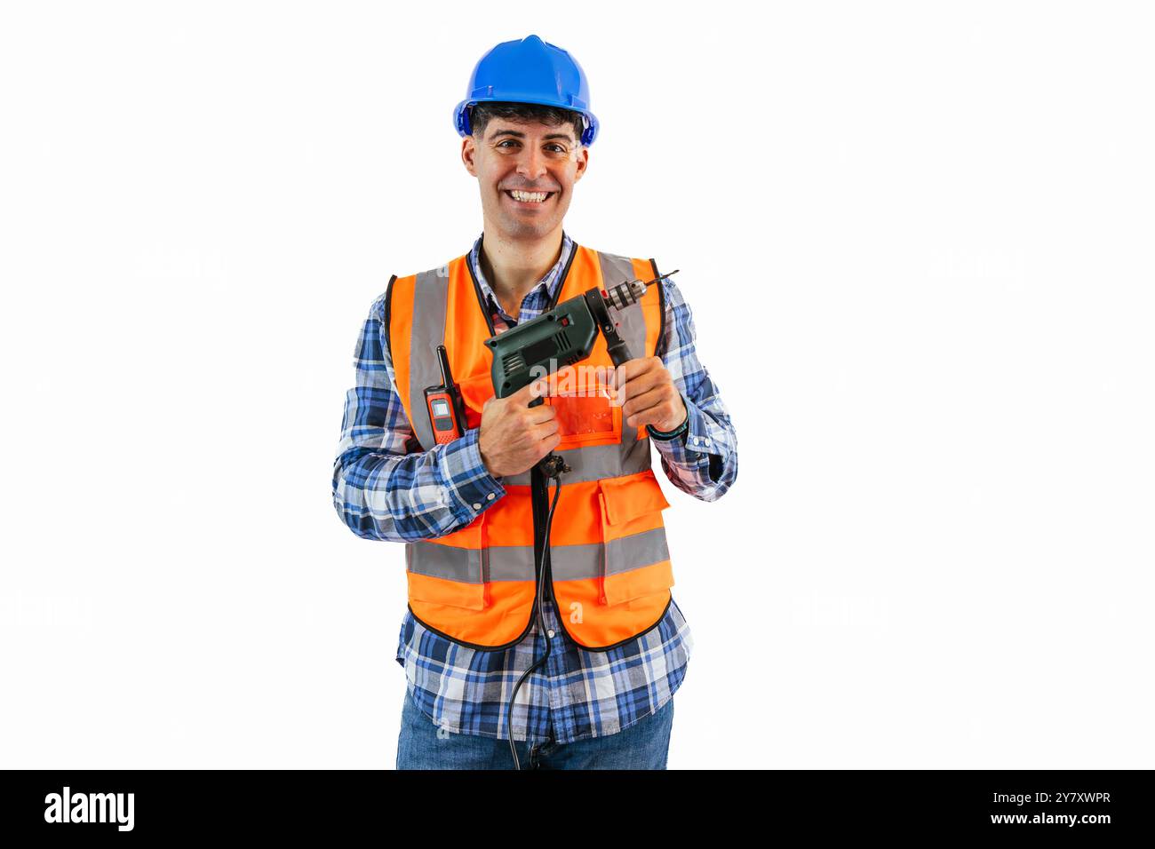 construction worker in an orange reflective vest and safety helmet smiles while holding a drill ...