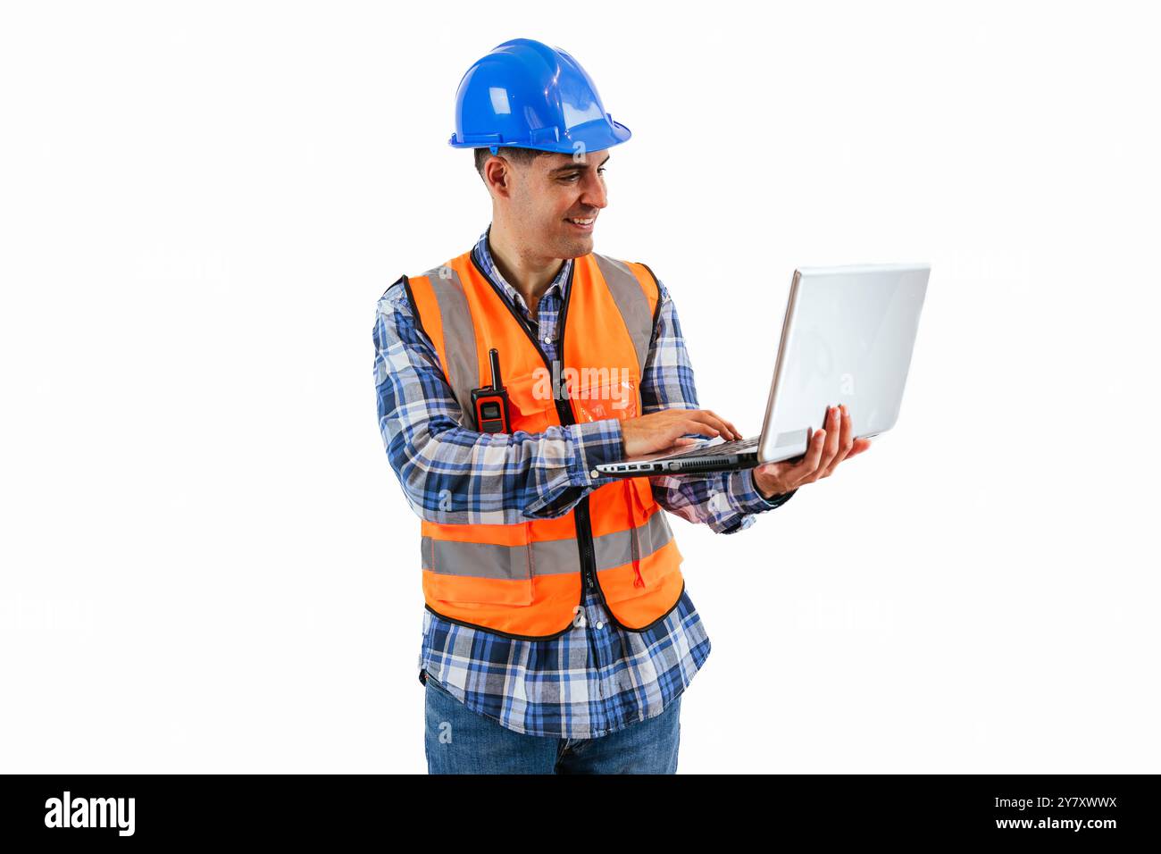 engineer wearing a reflective vest and safety helmet works on a laptop ...