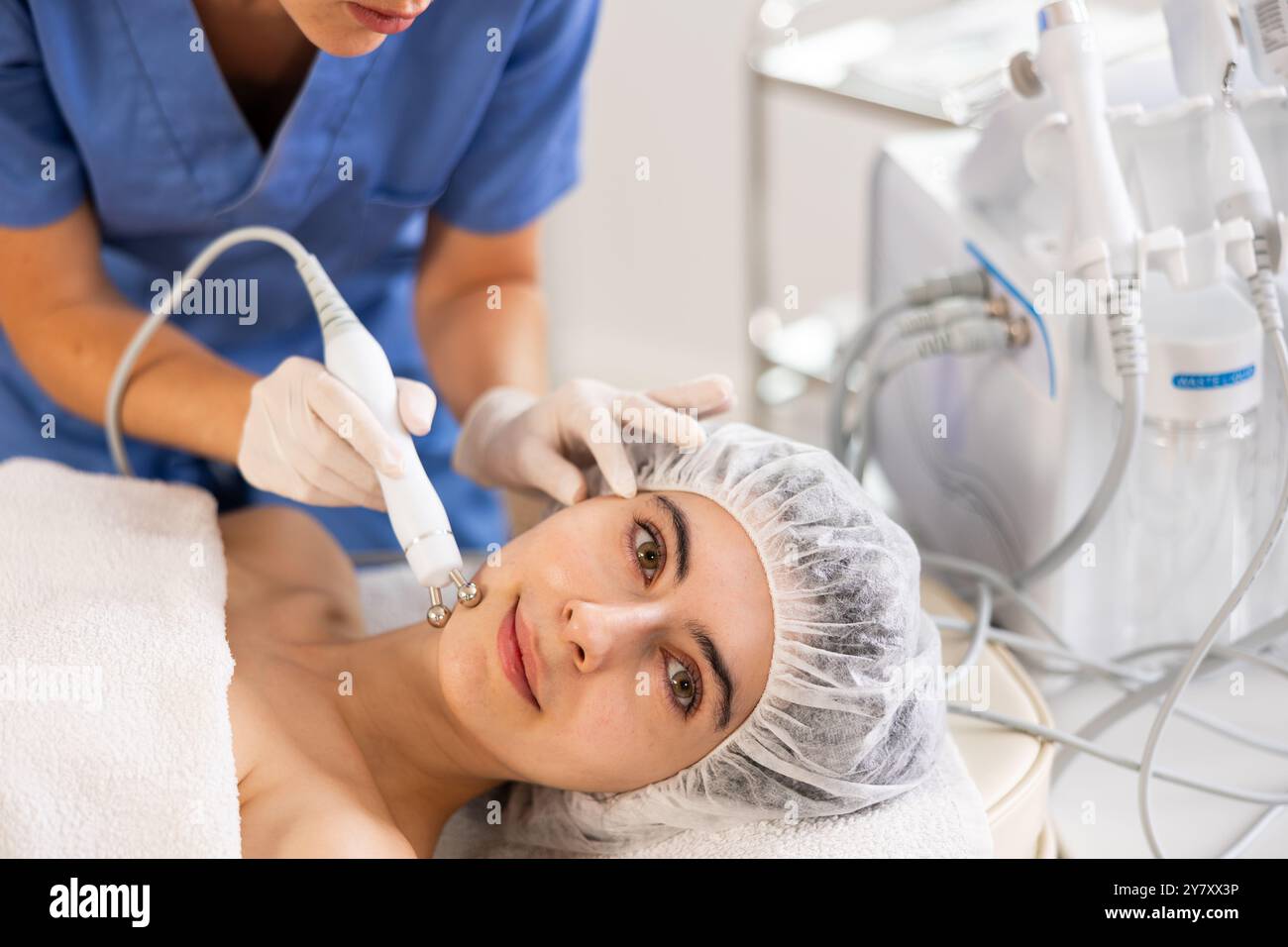 Female client getting face skin rf lifting procedure in cosmetic clinic ...