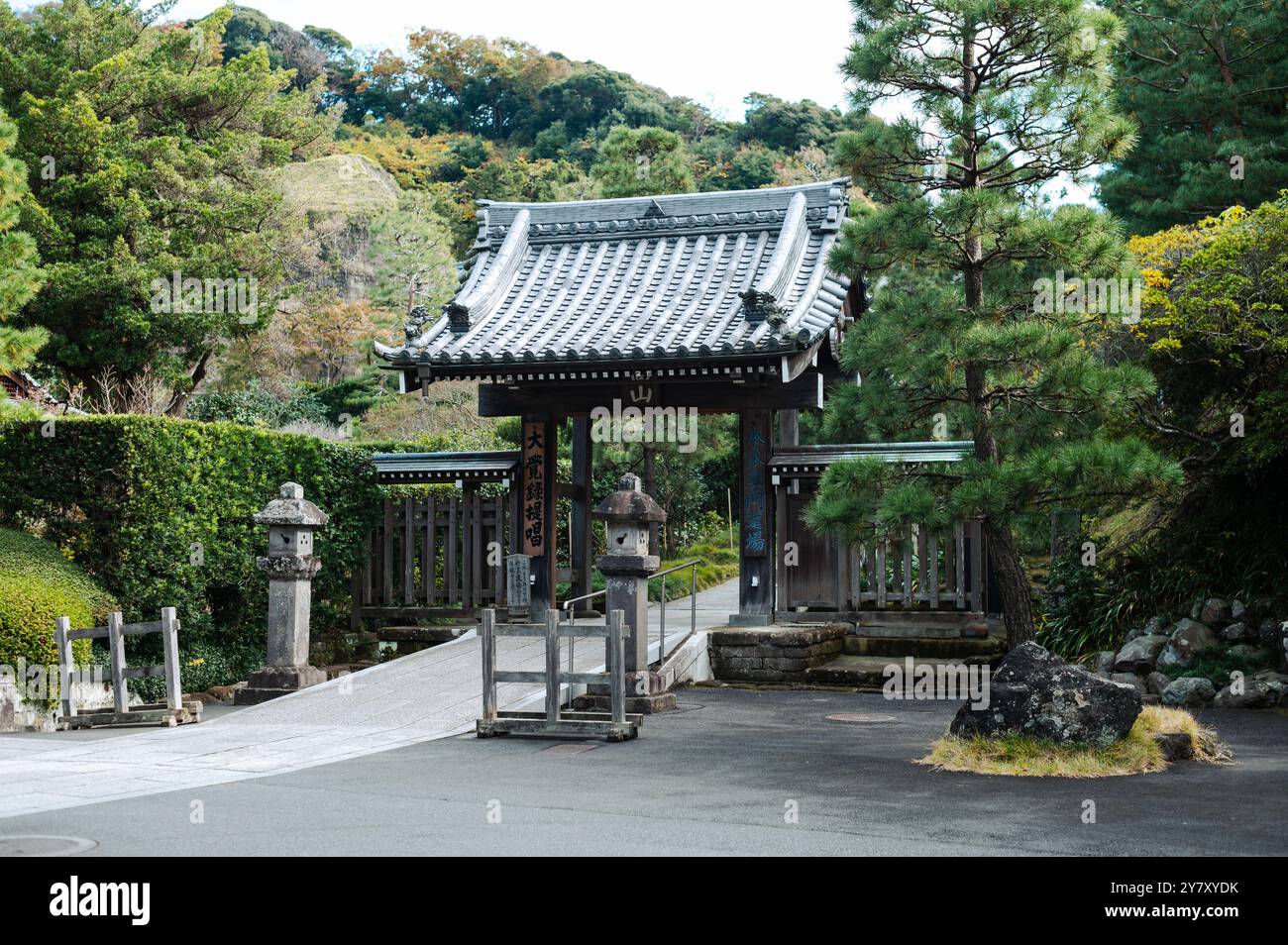 A traditional Japanese gate with a tiled roof stands at the entrance to ...