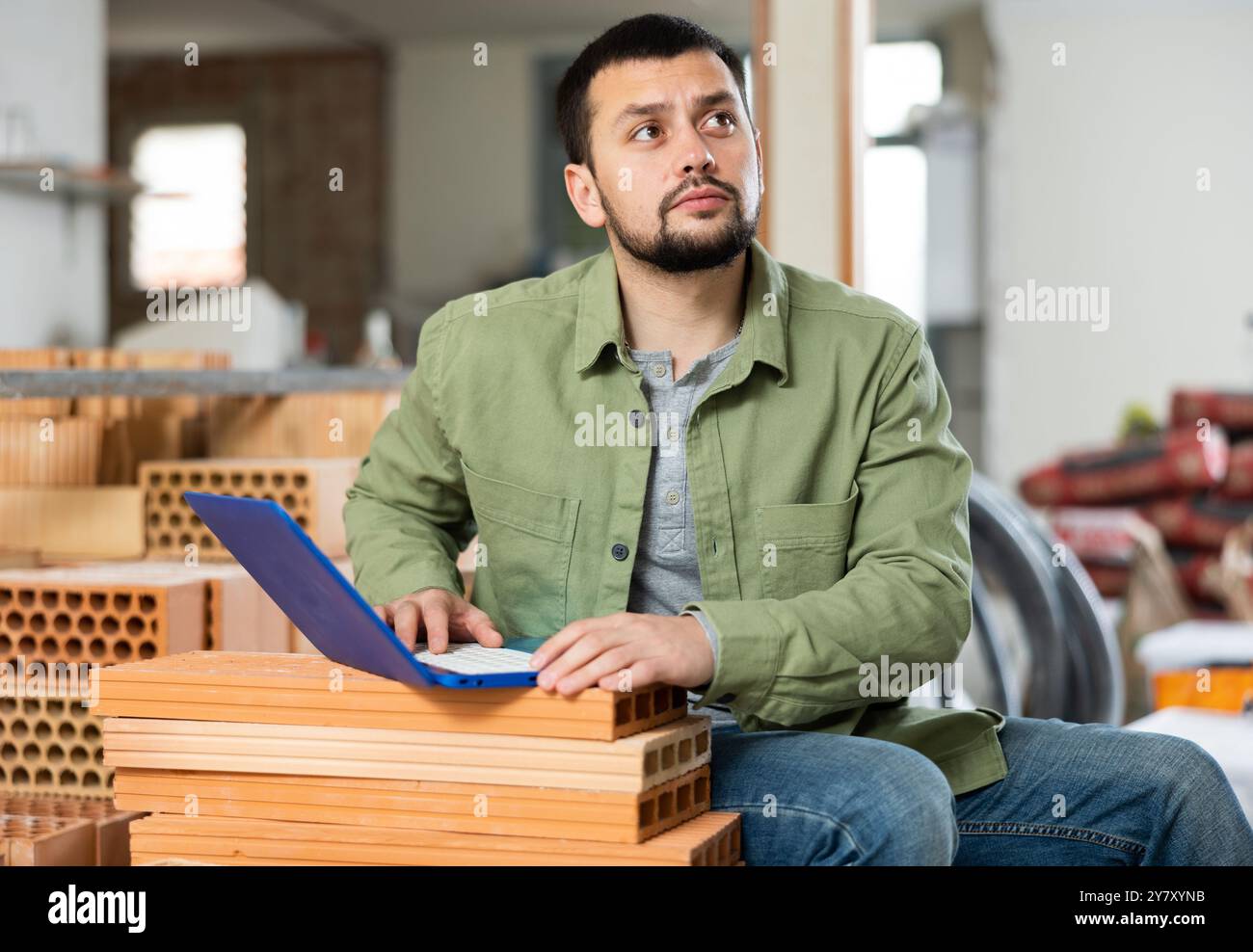 Civil engineer monitors the process of capital repairs on a laptop ...