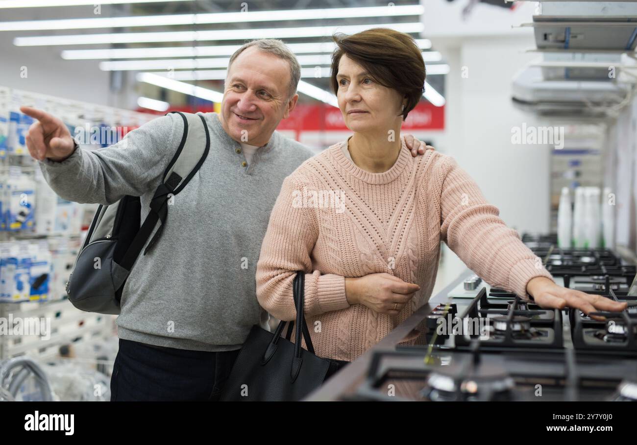 Middle aged wife and husband picking new gas stove in store Stock Photo ...