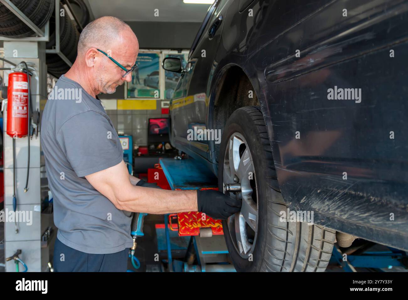 Car wheels maintenance. Car tire wheel replace and mechanic staff ...