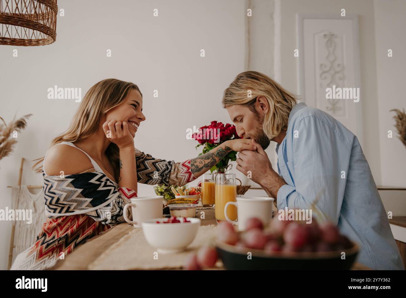 Romantic young man kissing hand of his girlfriend while enjoying ...