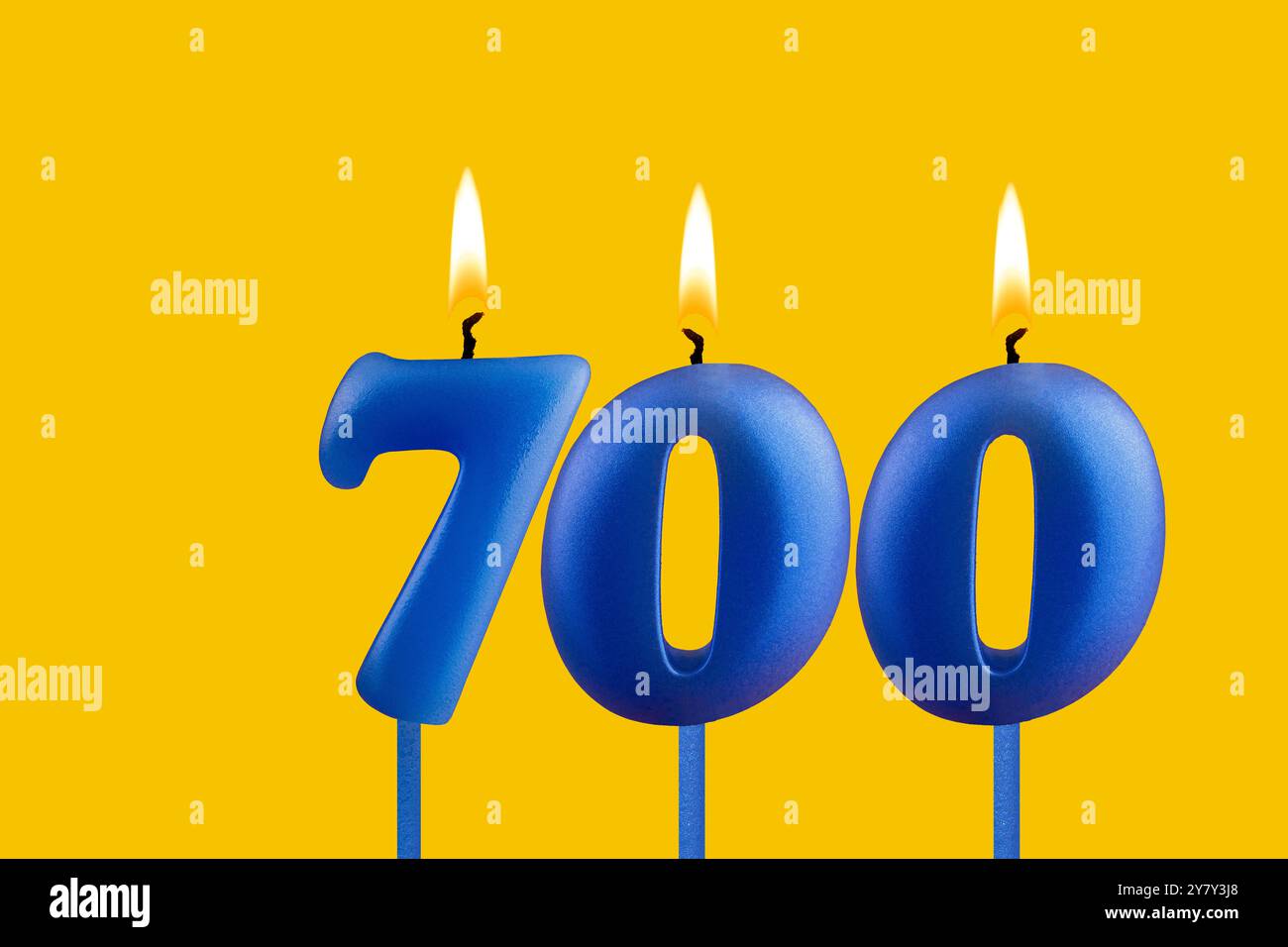 Blue birthday candle on yellow background - Number 700 Stock Photo - Alamy