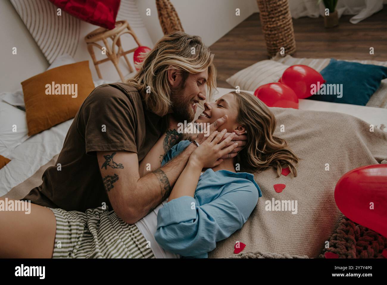 Romantic loving couple embracing face to face while lying in bed ...