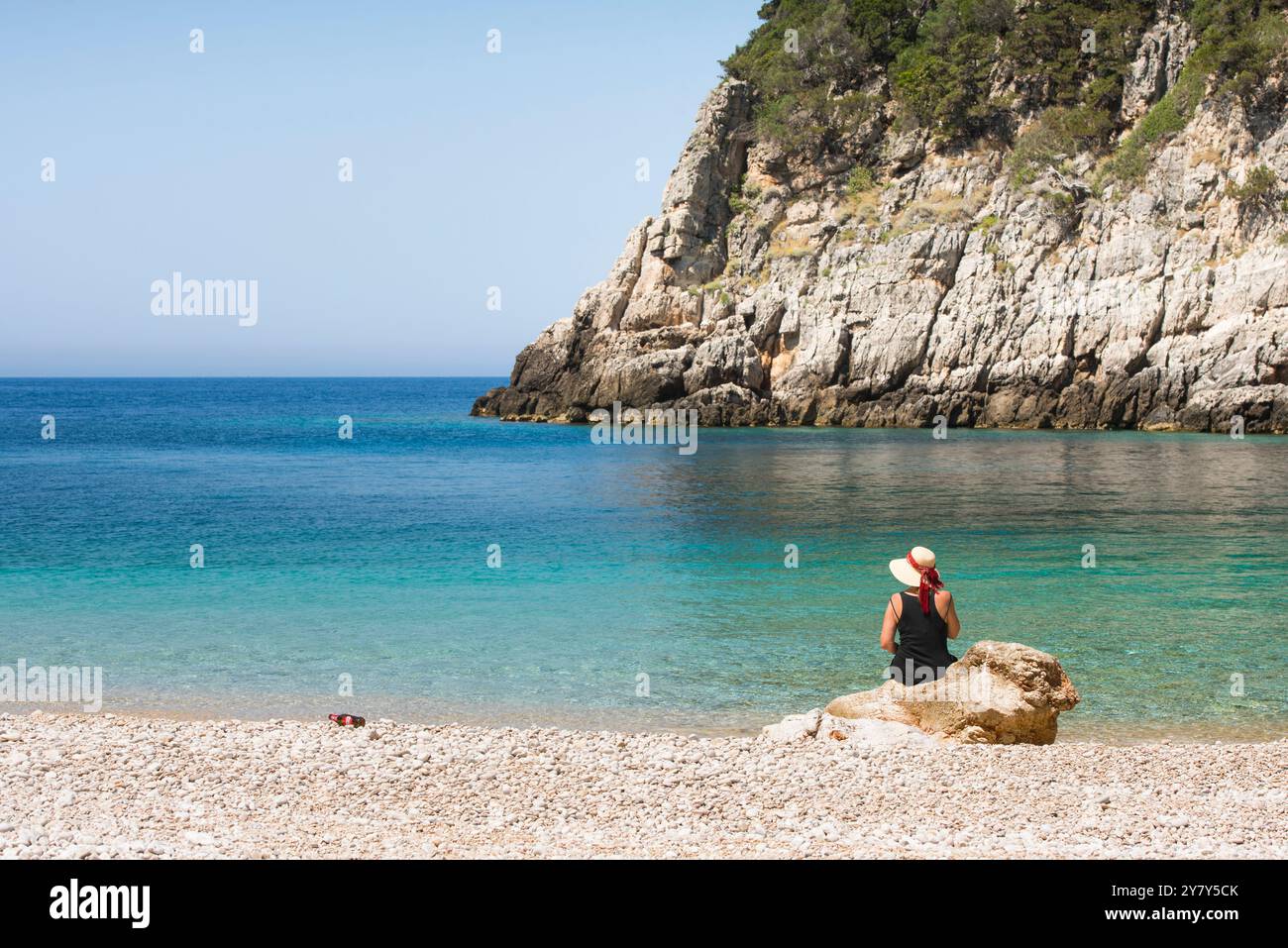 Woman sitting on a rock at the Beach of Dafines bay, Peninsula of ...